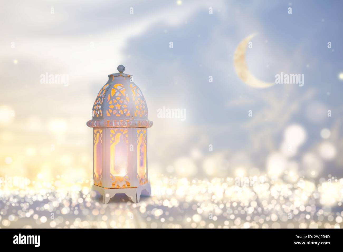 Ramadan Kareem greeting. Islamic lantern near mosque with night sky with crescent moon and stars ...