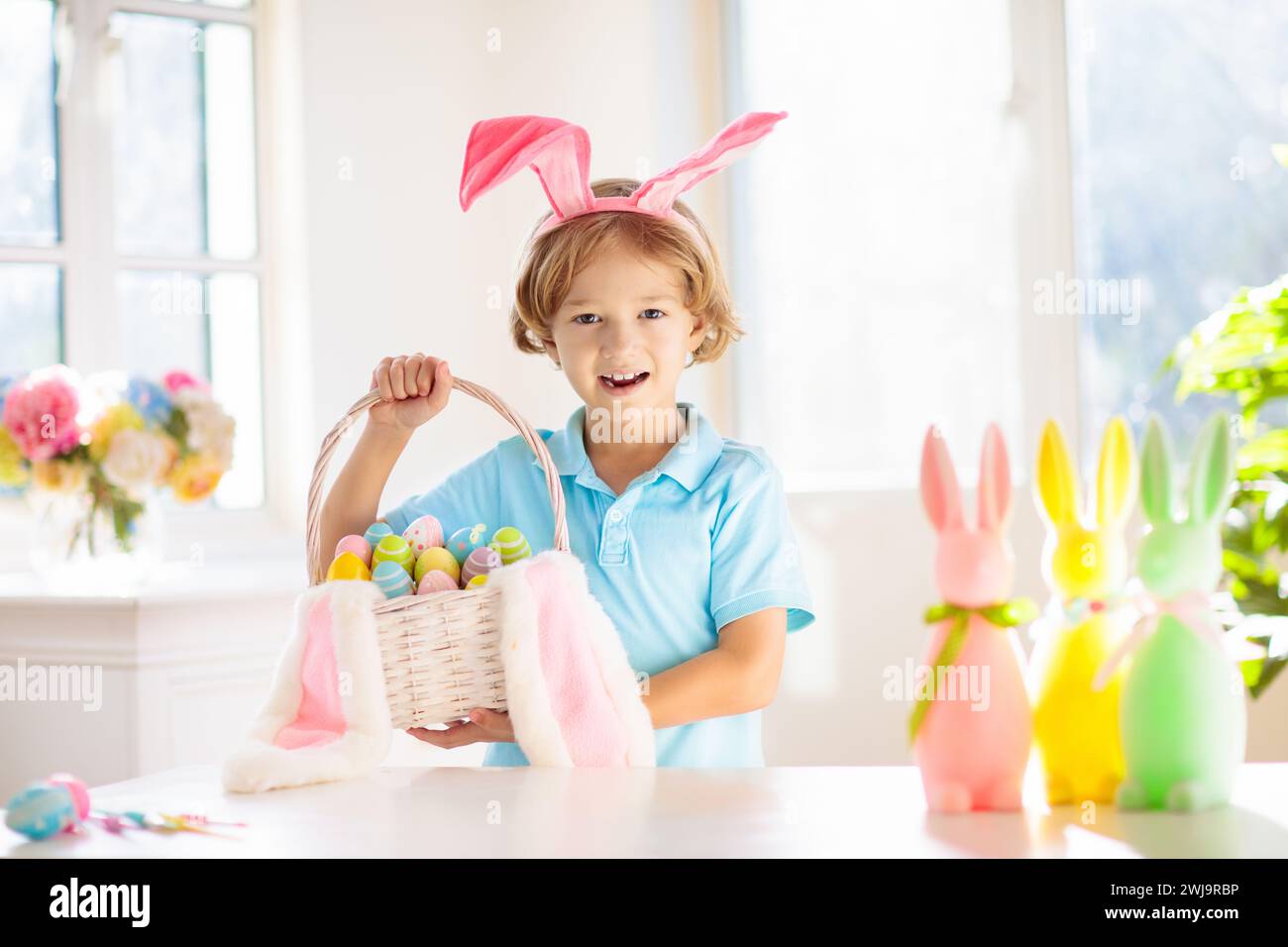 Kids dyeing Easter eggs. Children in bunny ears dye colorful egg for ...