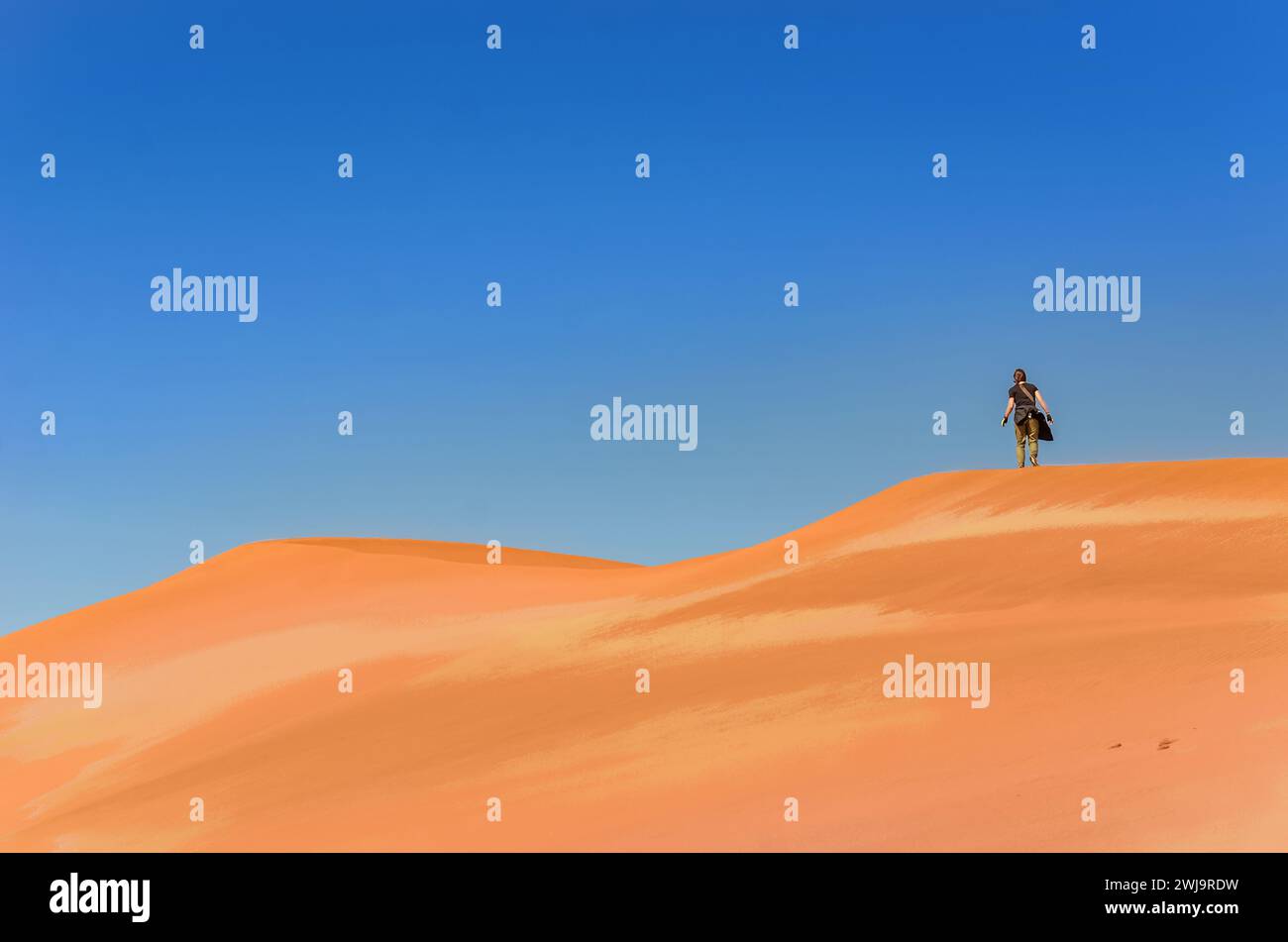 Tourist walking on beautiful sunrise red sand dunes, african adventure ...