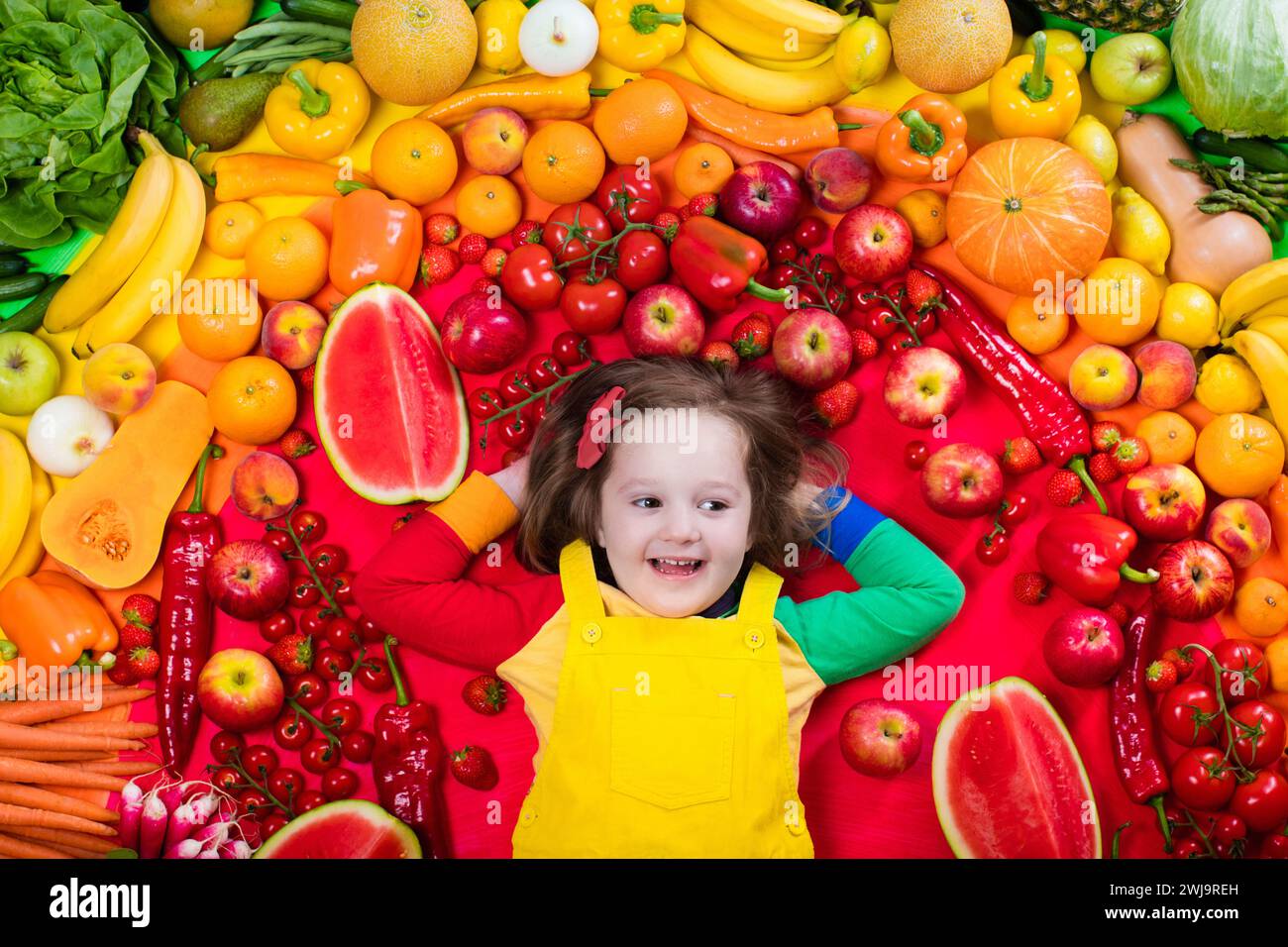 Little girl with variety of fruit and vegetable. Colorful rainbow of ...