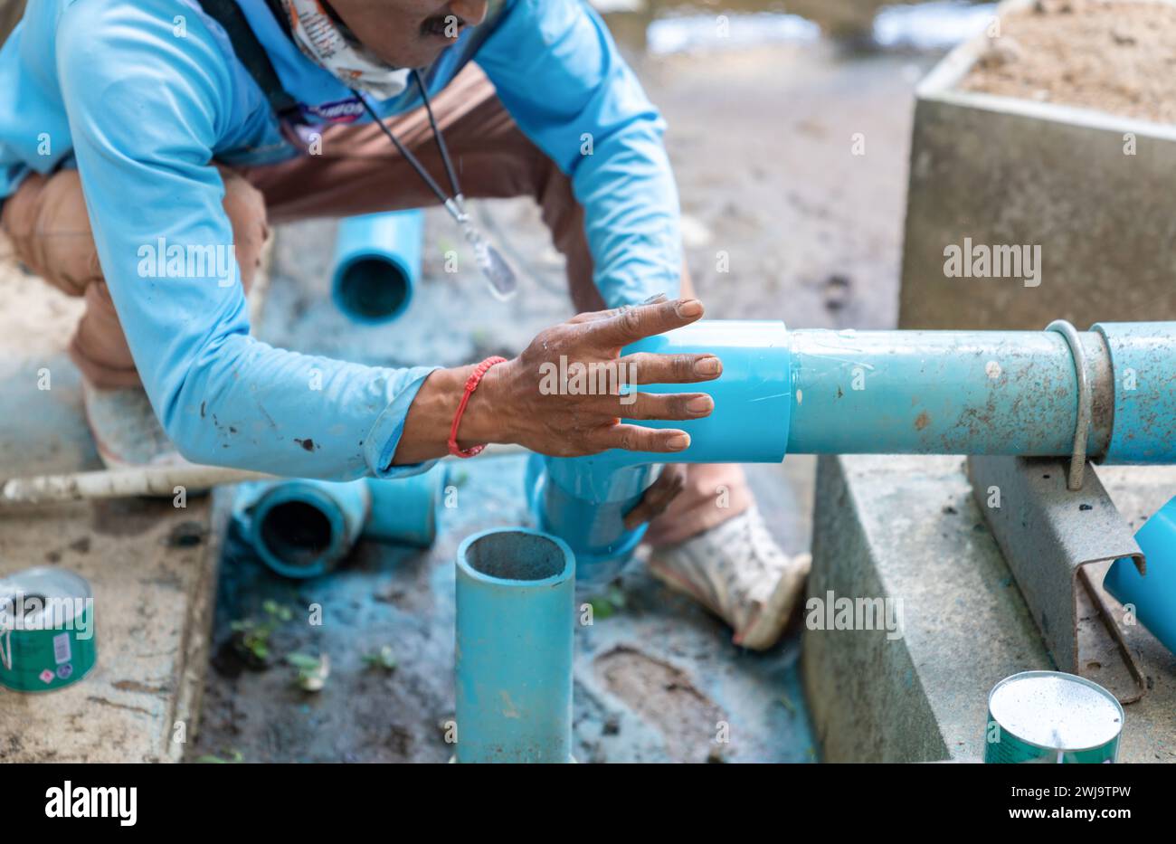 Worker fixing the connecting tube of water tank in construction site ...