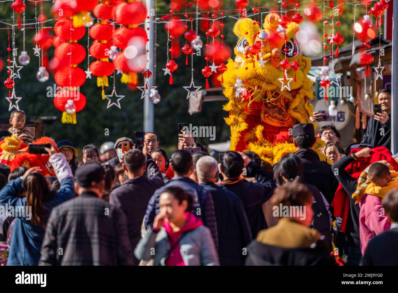 Bijie, China. 14th Feb, 2024. Tourists are watching a lion dance ...