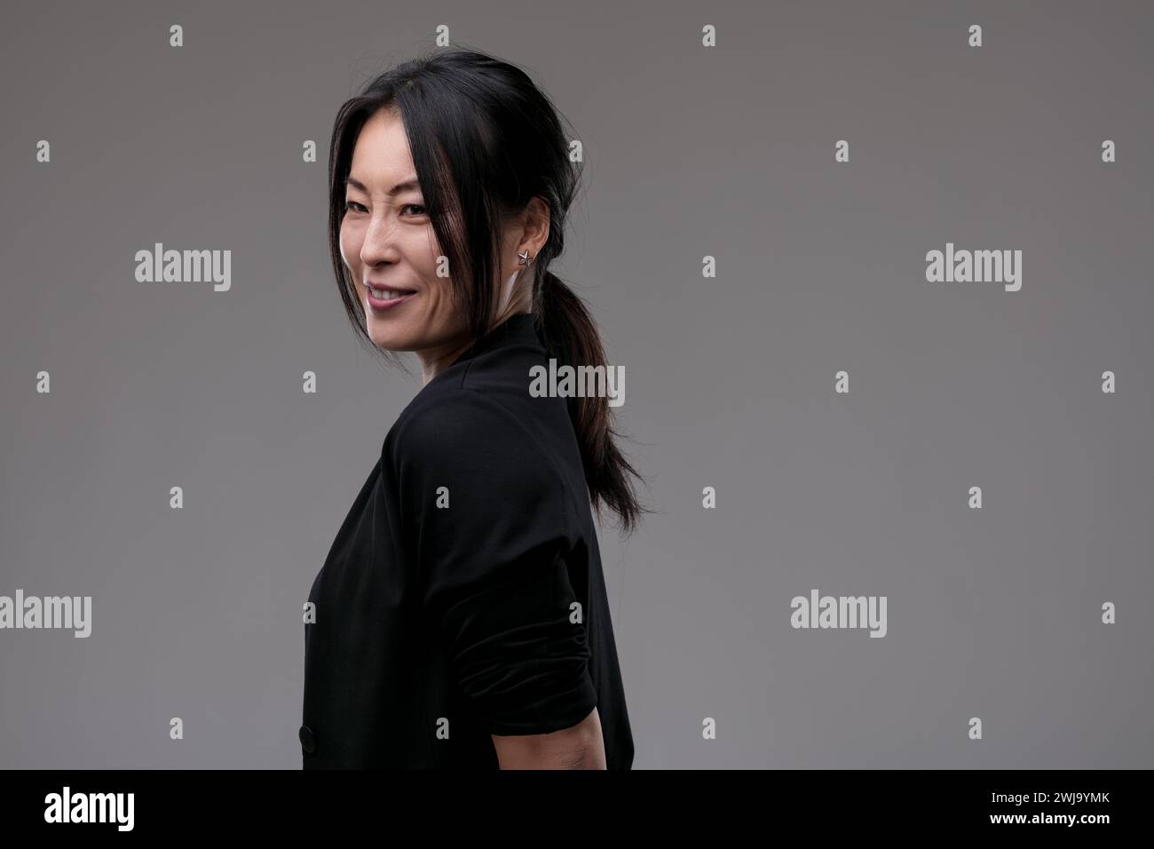 She offers a knowing smile over her shoulder, conveying a sense of ...