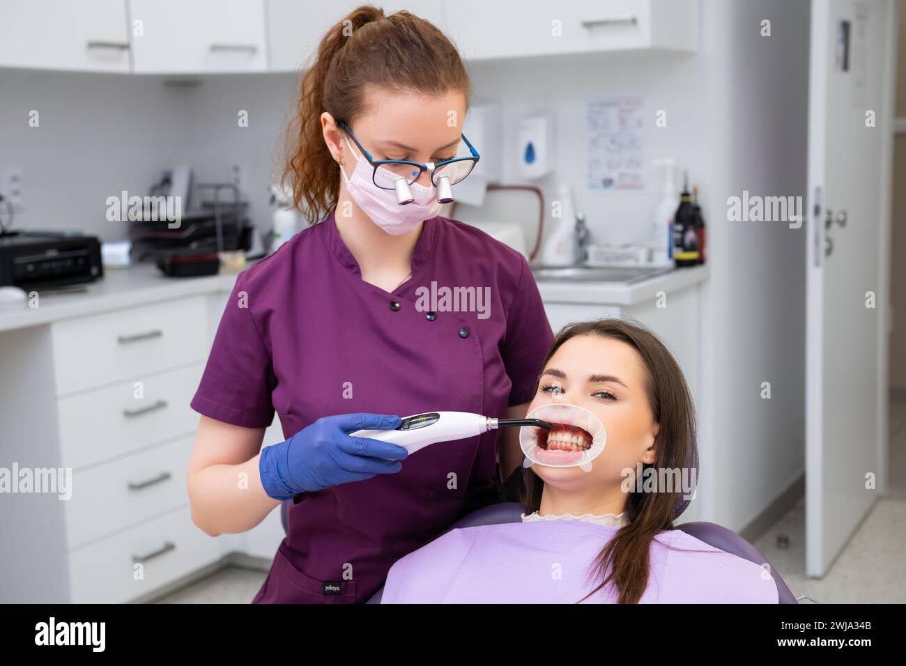 Dentist uses UV light completing dental filling procedure at ...