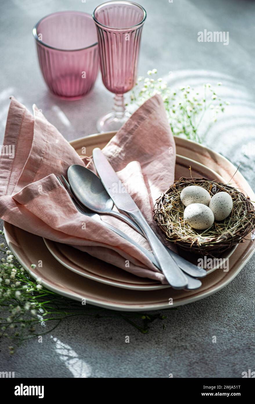 An elegant Easter dining setup featuring a nest with speckled eggs ...