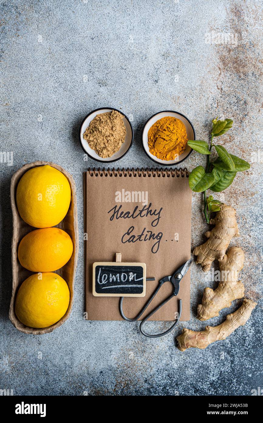 A notepad labeled healthy Cooking with a pen, fresh lemons, ginger ...