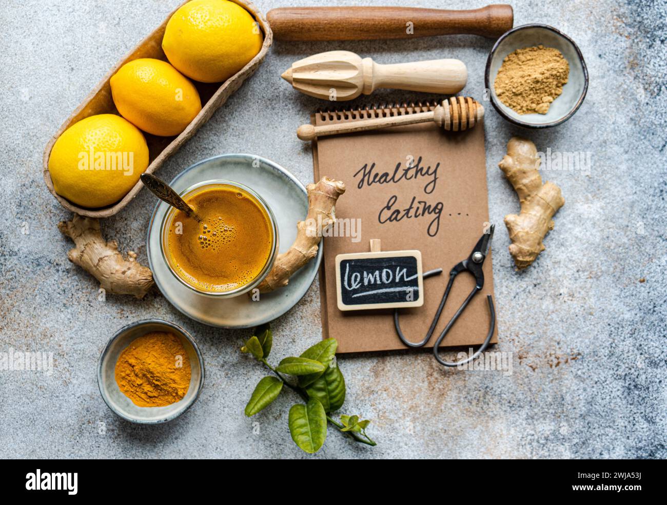 A flat lay composition featuring lemons, ginger, honey, and spices ...