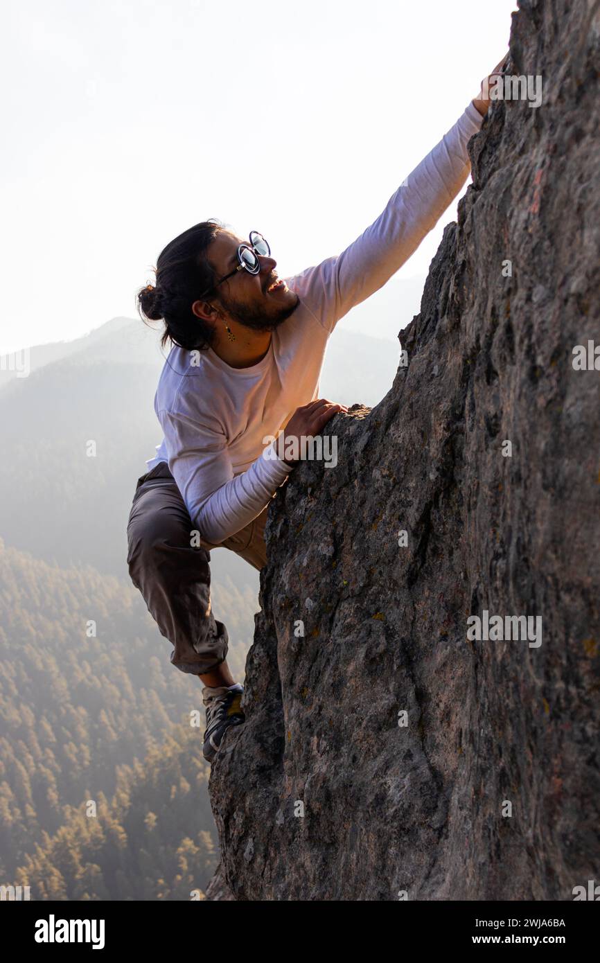 Full body of positive male in stylish clothes and sunglasses climbing ...