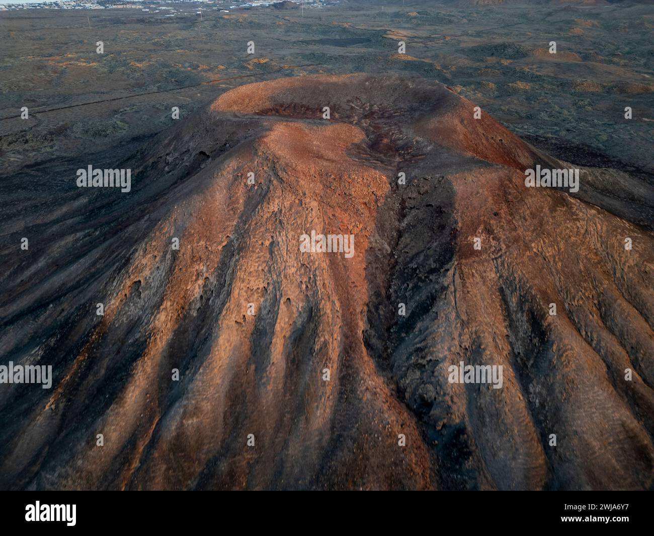 An aerial shot captures the eerie beauty of a dormant volcanic crater with its hardened lava ...