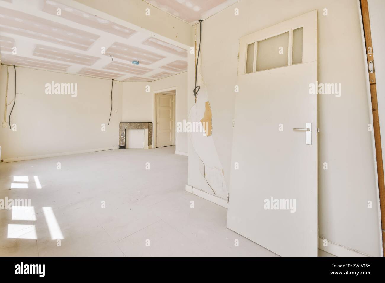 An empty room under renovation showcasing exposed ceiling beams, a ...