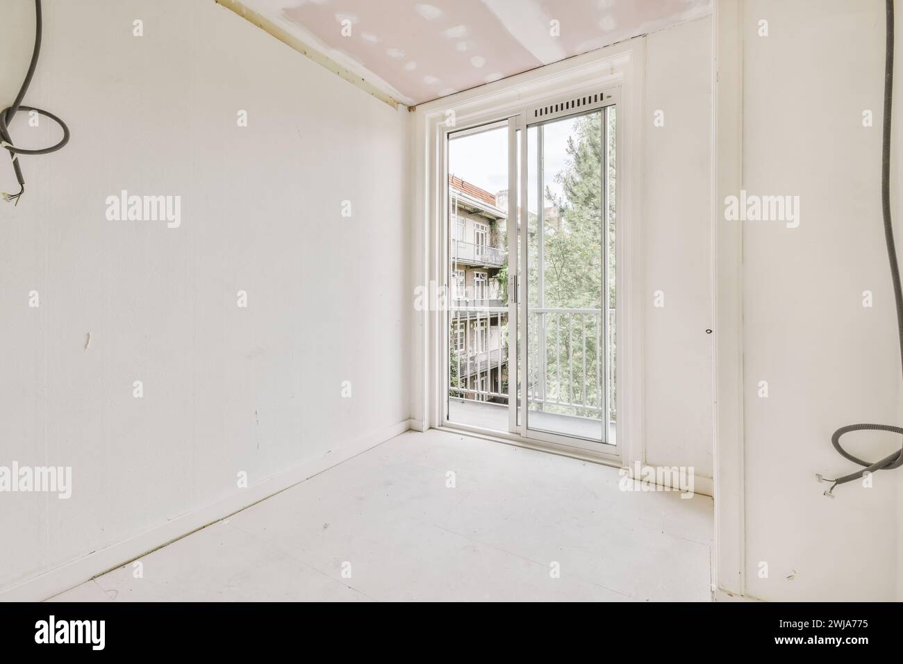 An empty, unfinished interior space with a large window leading to a ...