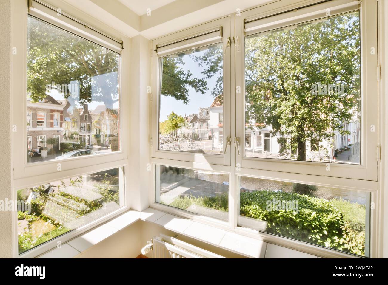 Open windows bring natural light into a room while offering a view of a ...
