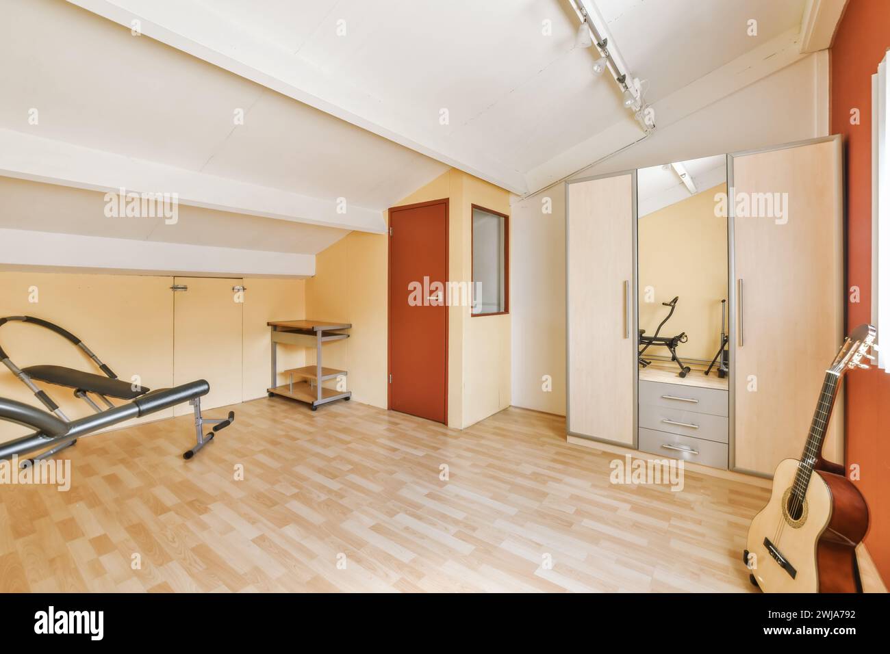 Home office setup featuring a desk, ergonomic chair, workout bench ...