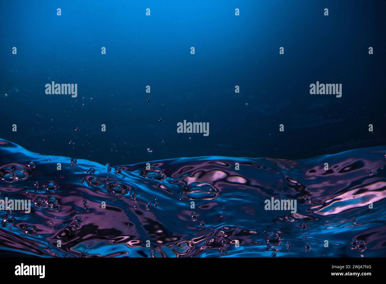 A serene image of deep dark blue water with gentle ripples and a ...
