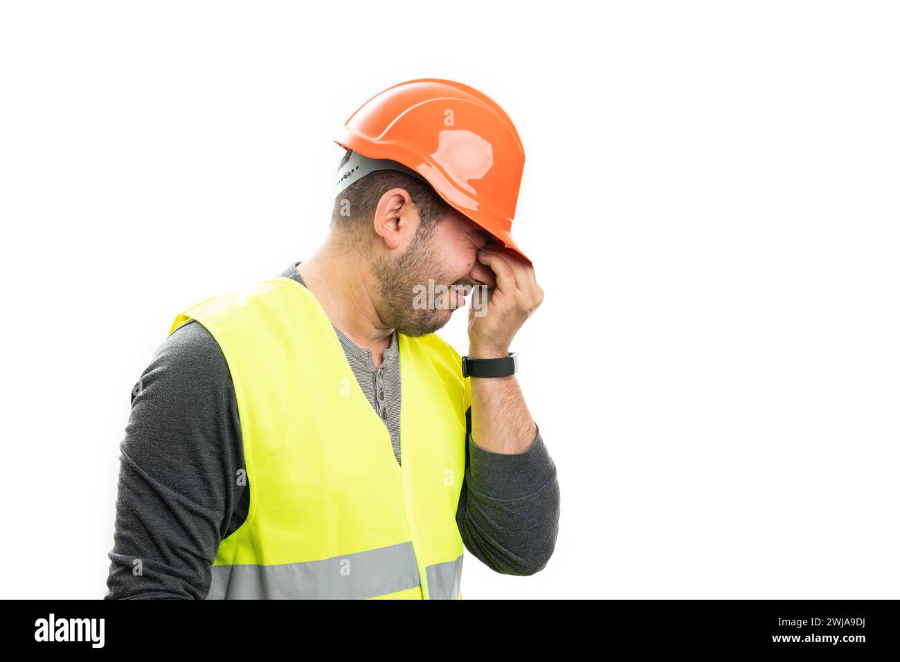 Stressed adult builder man in work uniform and orange safety helmet ...