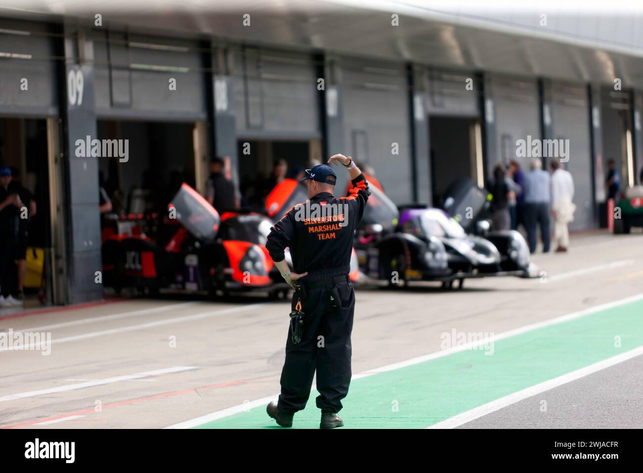 A Silverstone marshal helping to muster the LMP race cars for the ...