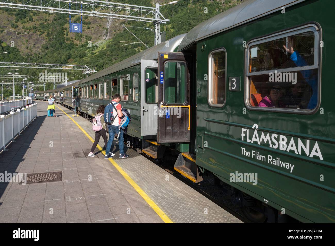 The famous Flåmsbana (Flåm Railway) train waiting at the platform in Flåm before heading up to ...