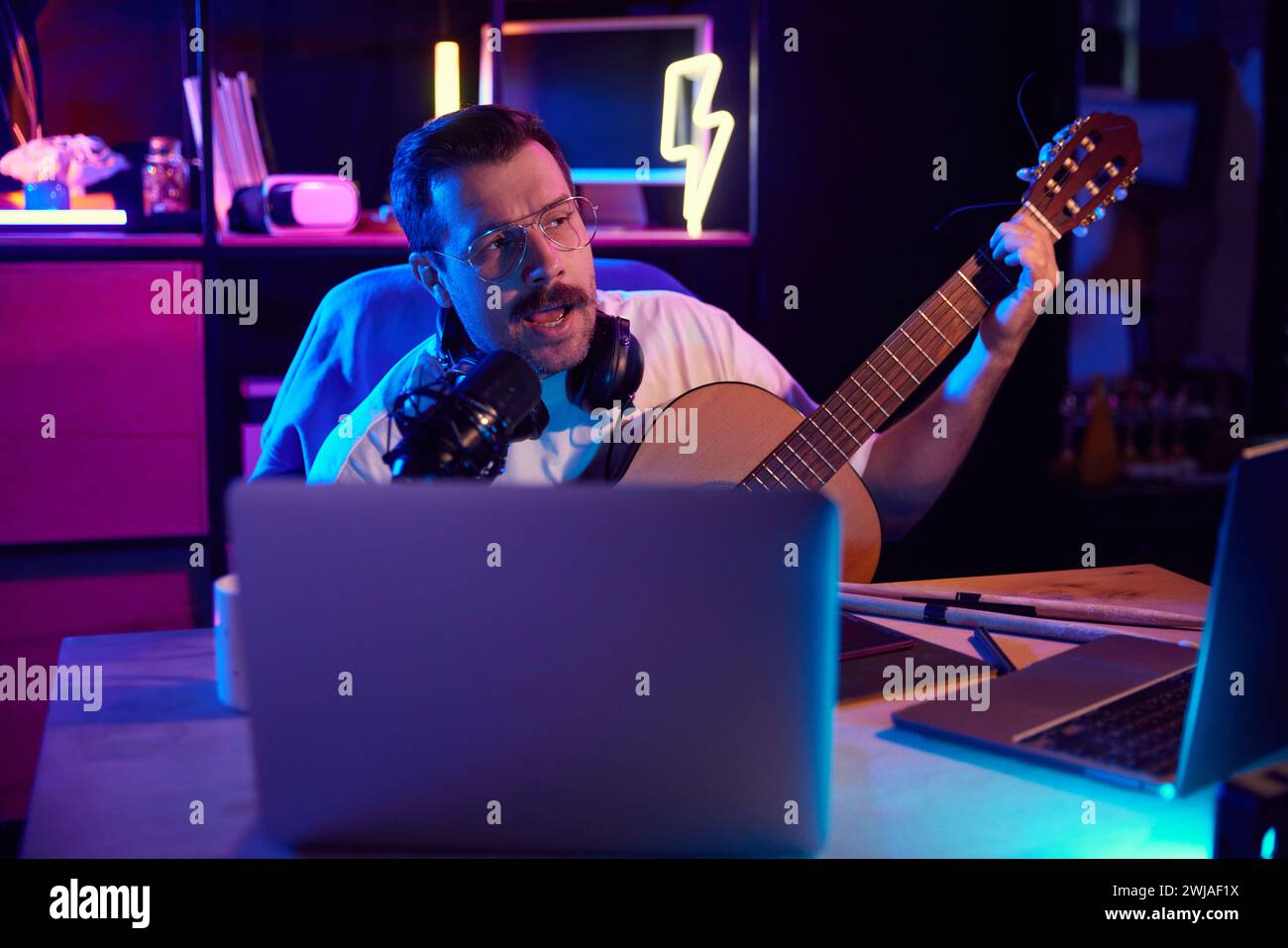 Artist composing music, vocalist playing on acoustic guitar in front of ...