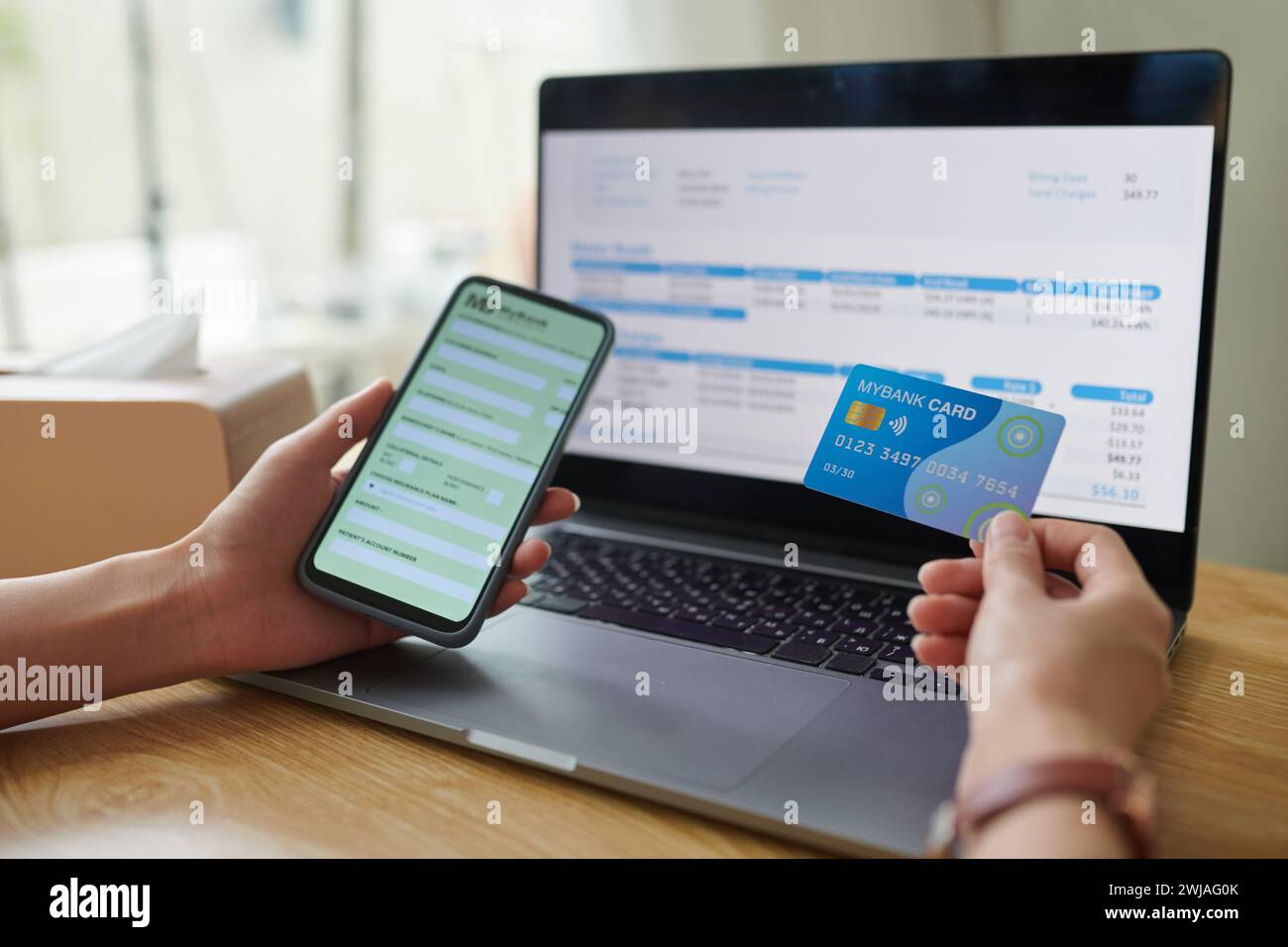 Woman entering information from credit card when paying utility bills ...