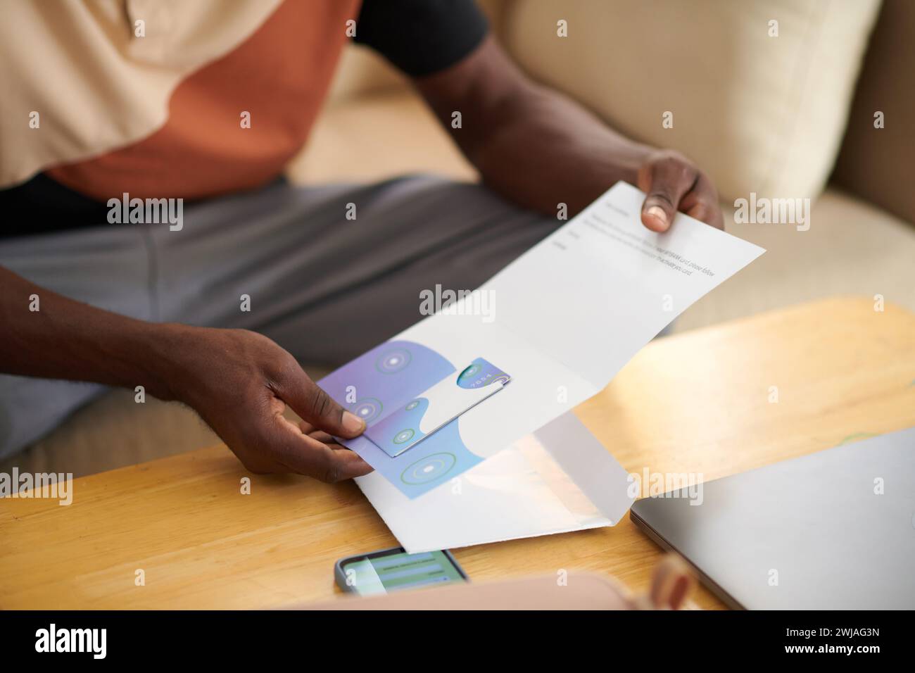 Hands of Black man opening bank letter and taking out credit card Stock ...