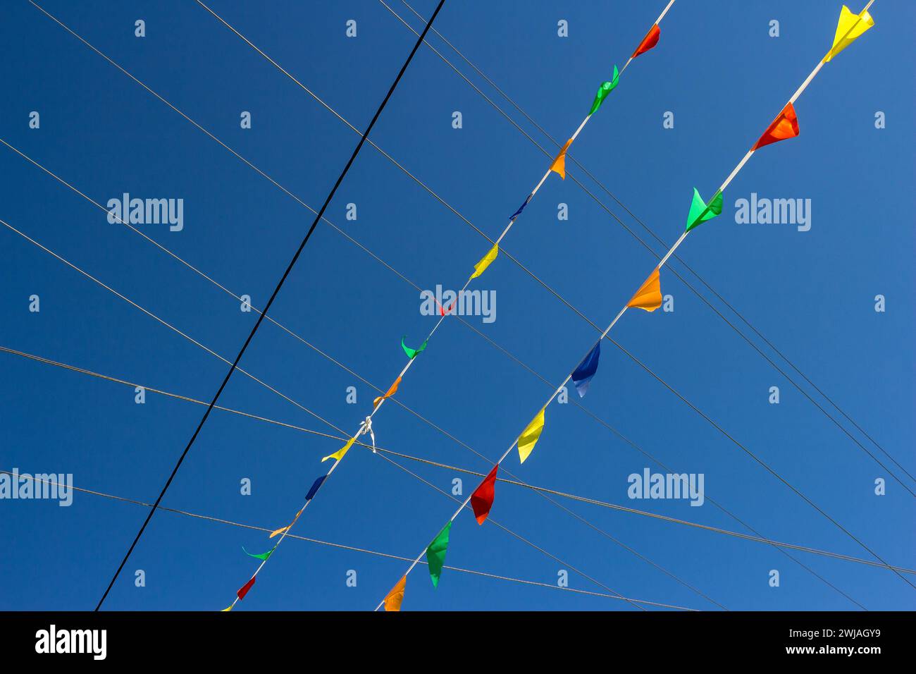 Intersection of stretched colored flags with power lines Stock Photo ...