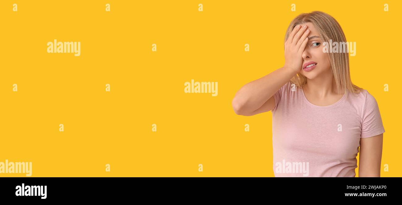 Young woman doing facepalm on yellow background with space for text ...
