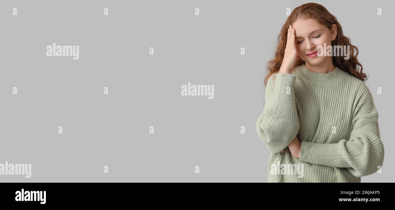 Young woman feeling awkward on grey background with space for text ...