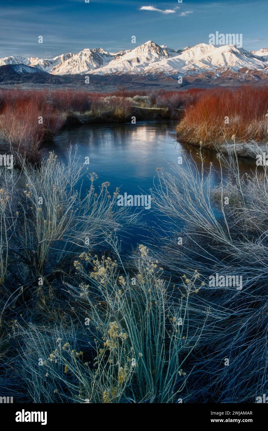 A scenic landscape view across a river with distant mountains in ...