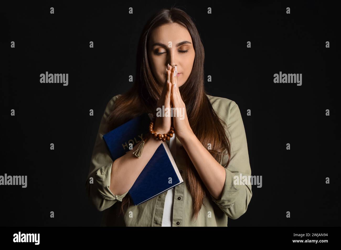 Beautiful woman with Holy Bible praying on black background Stock Photo ...