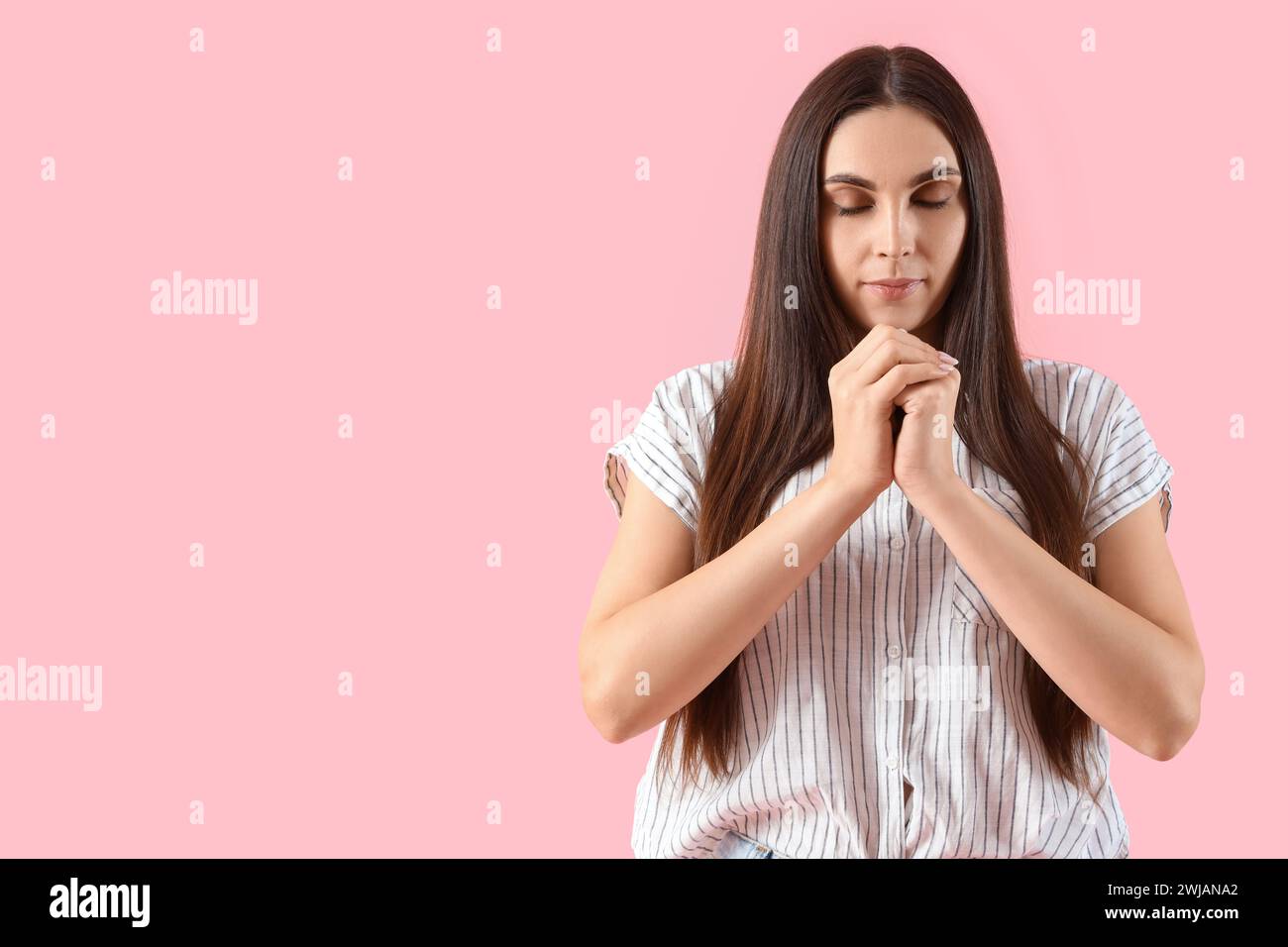 Beautiful woman praying on pink background Stock Photo - Alamy
