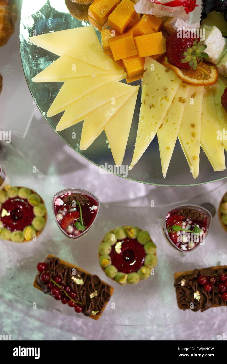 Colorful and delicious canapes and desserts on a glass shelf at a ...