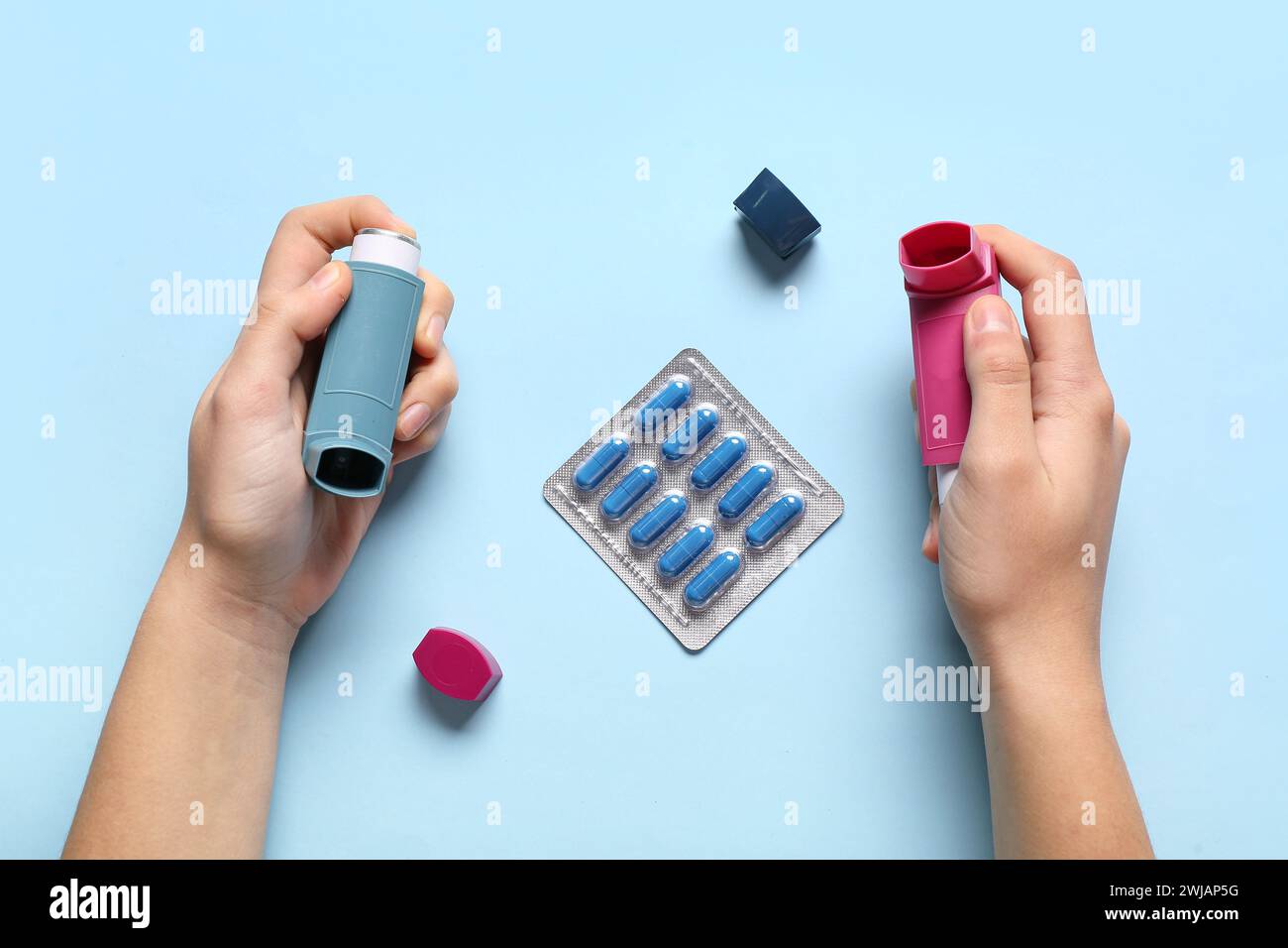 Child's hands with asthma inhalers and pills on blue background Stock ...