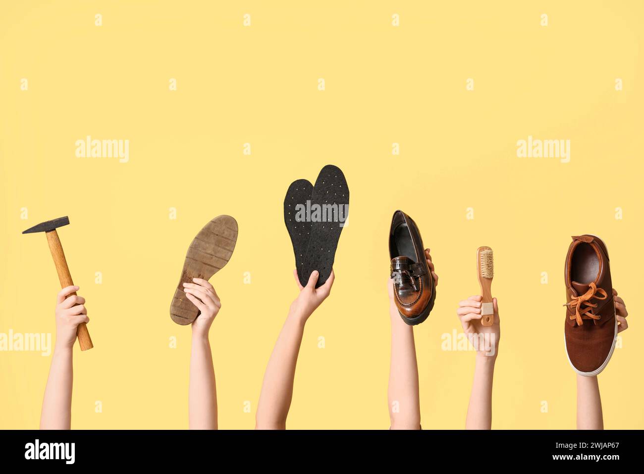 Female hands with shoes, hammer and insoles on yellow background. Shoe ...