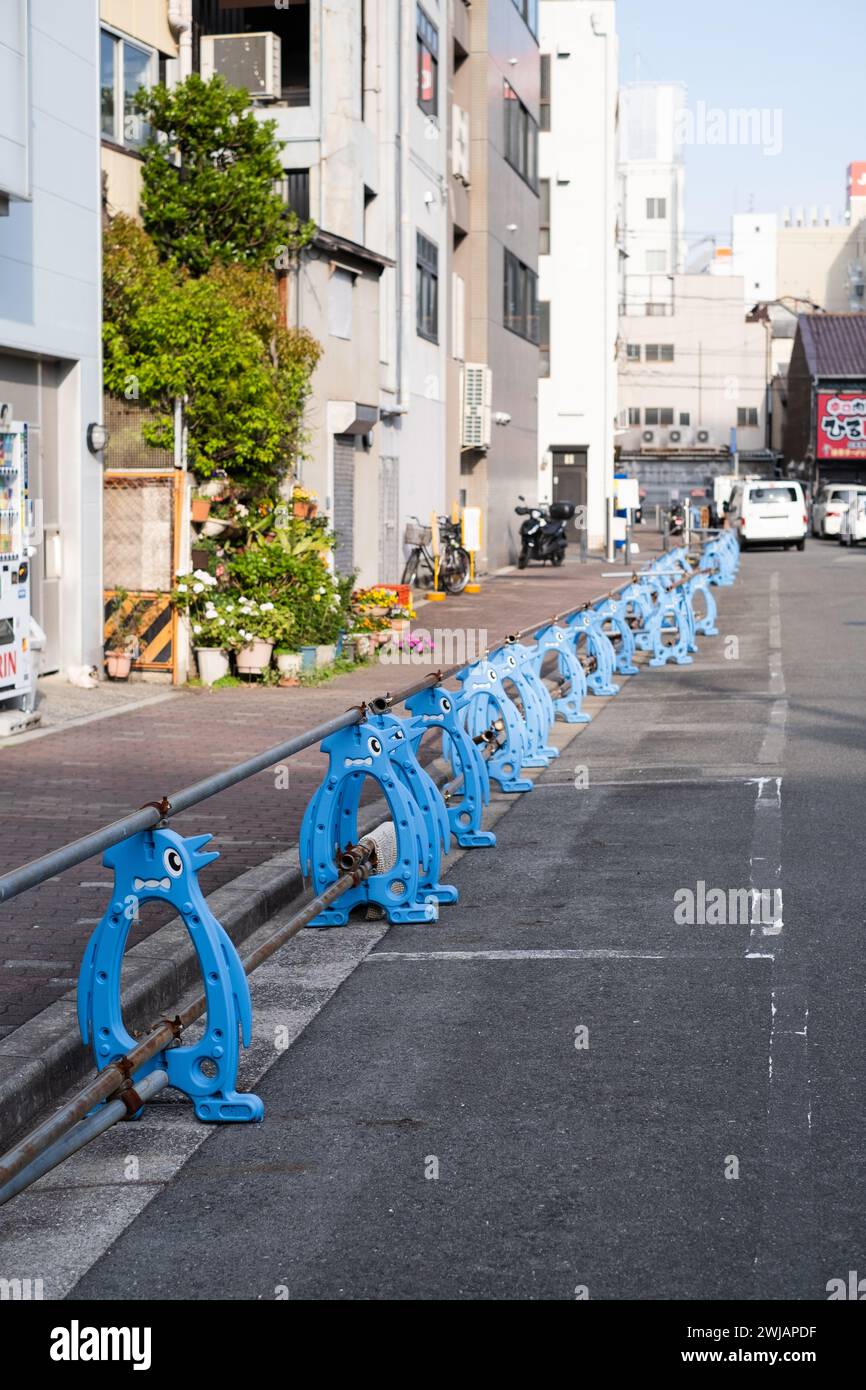 Street scene in Osaka, Japan, with blue penguin-shaped barriers along ...