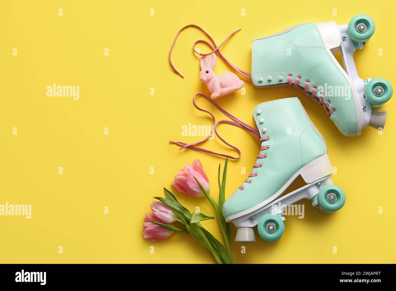 Vintage roller skates with beautiful tulips and toy bunny on yellow ...