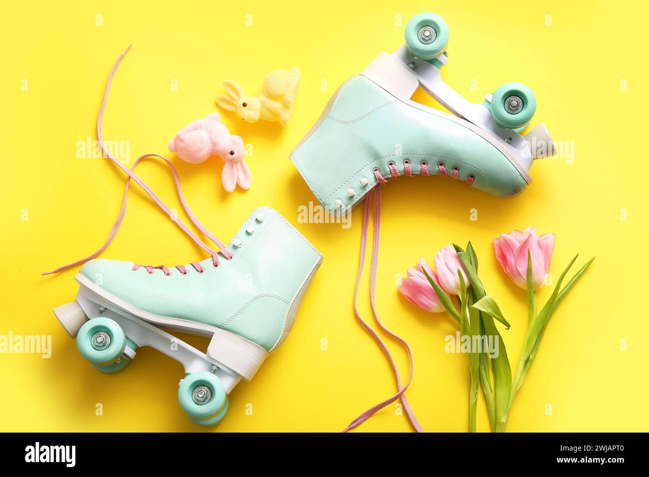 Vintage roller skates with beautiful tulips and toys bunny on yellow ...