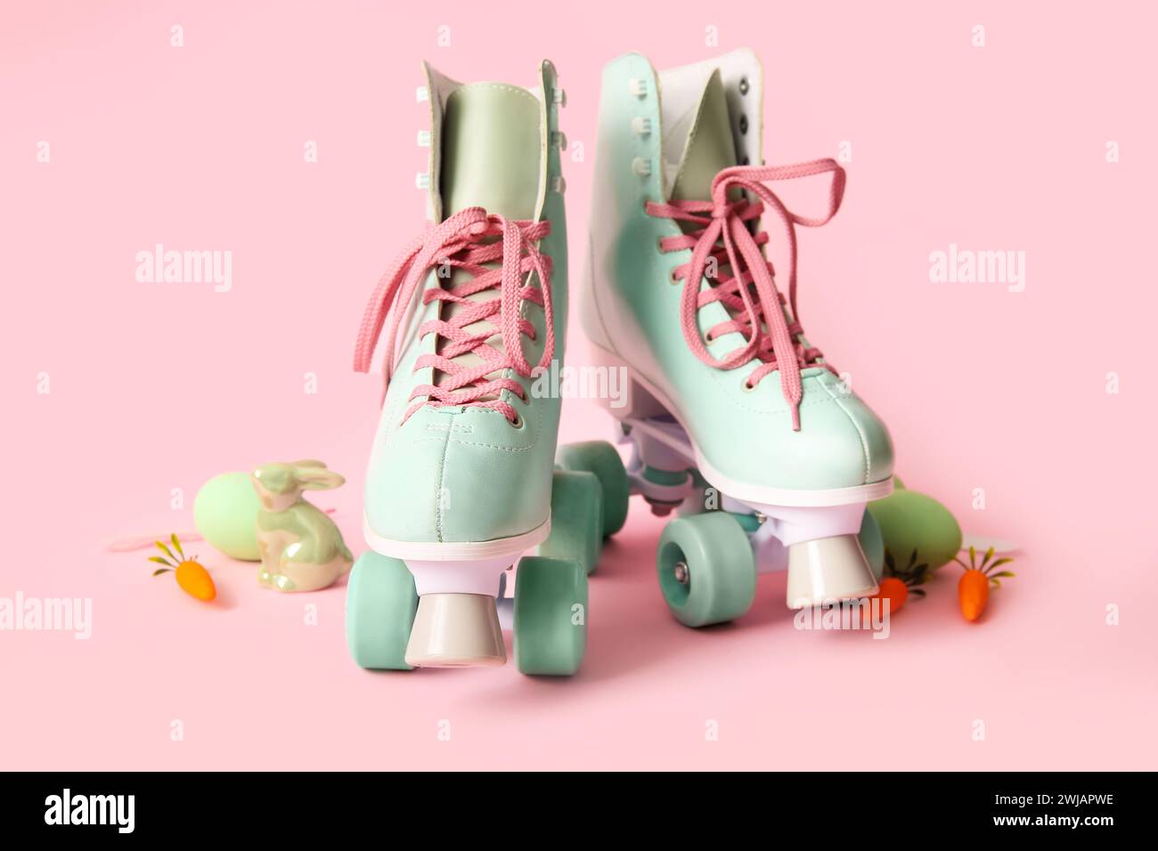 Vintage roller skates with Easter eggs, carrots and toy bunny on pink ...