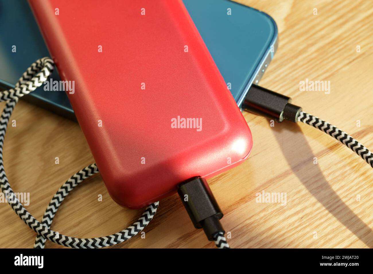 Back of red and blue mobile phones connected to charging cables Stock ...