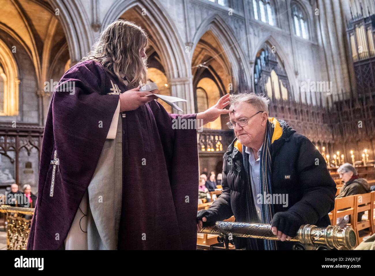 Canon Claire Renshaw makes an ash cross on the forehead of a ...