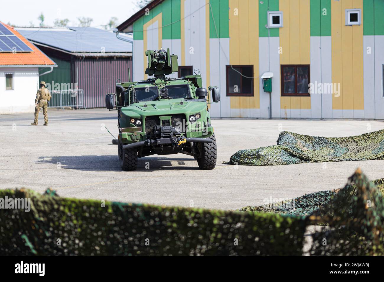 A green armored and camouflaged military vehicle driving at a show ...