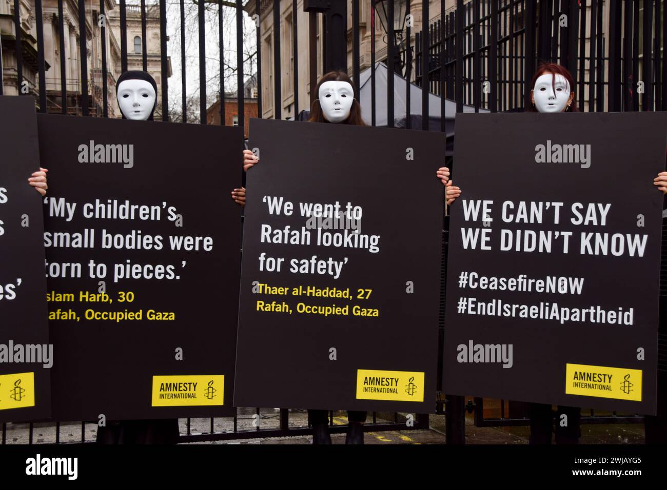 London, England, UK. 14th Feb, 2024. Amnesty UK activists donning masks ...