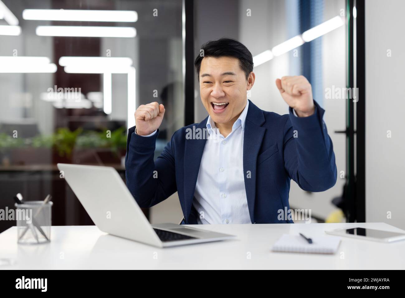 Joyful man dancing at workplace, successful asian businessman in ...