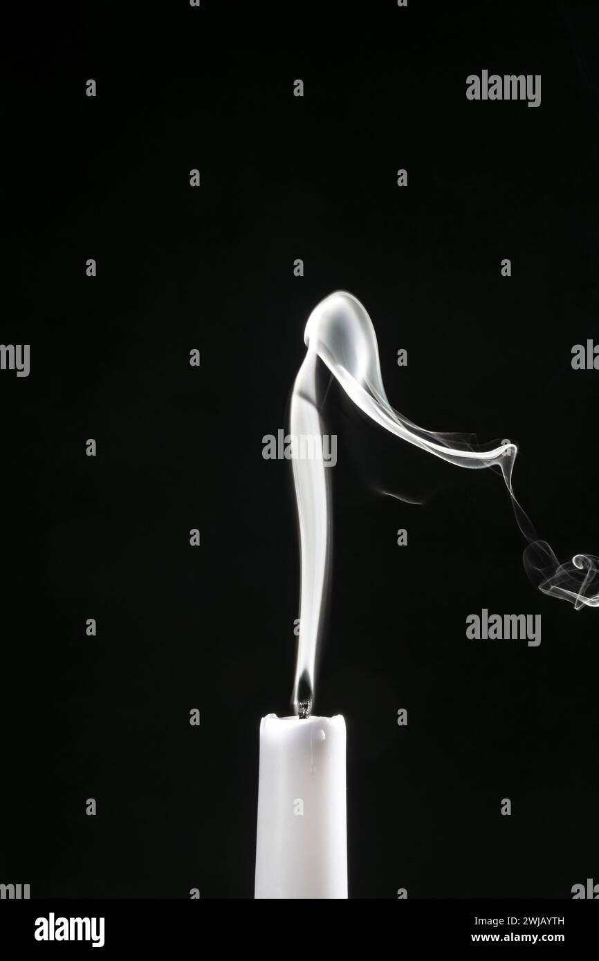 Smoke from an extinguished candle, closeup, seen against a black ...