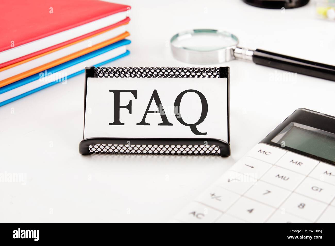 FAQ TEXT text on a business card next to office supplies on a white ...