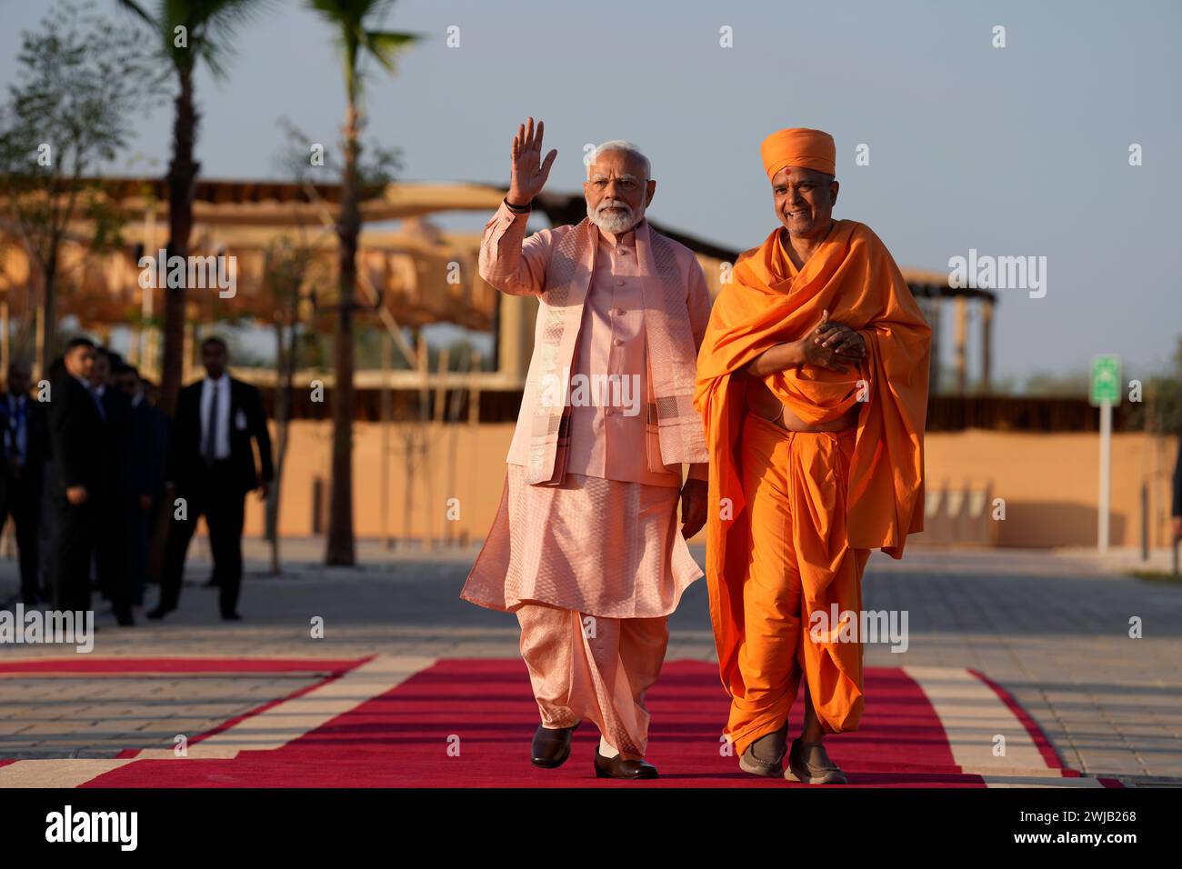Indian Prime Minister Narendra Modi, left, waves as he walks with Hindu ...