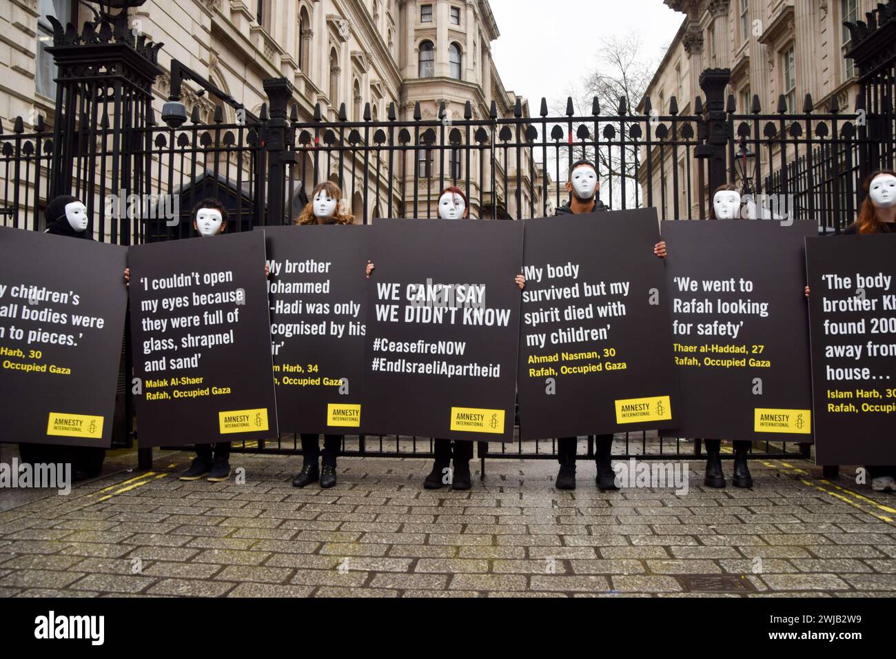 London, England, UK. 14th Feb, 2024. Amnesty UK activists donning masks ...