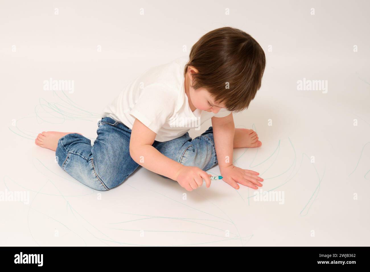 The child learns to draw on paper, studio white background. Toddler ...