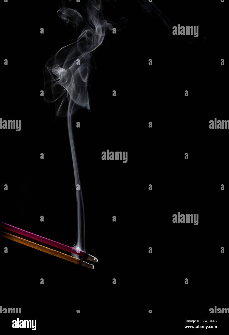 Two burning Incense Sticks with smoke on a black background Stock Photo ...