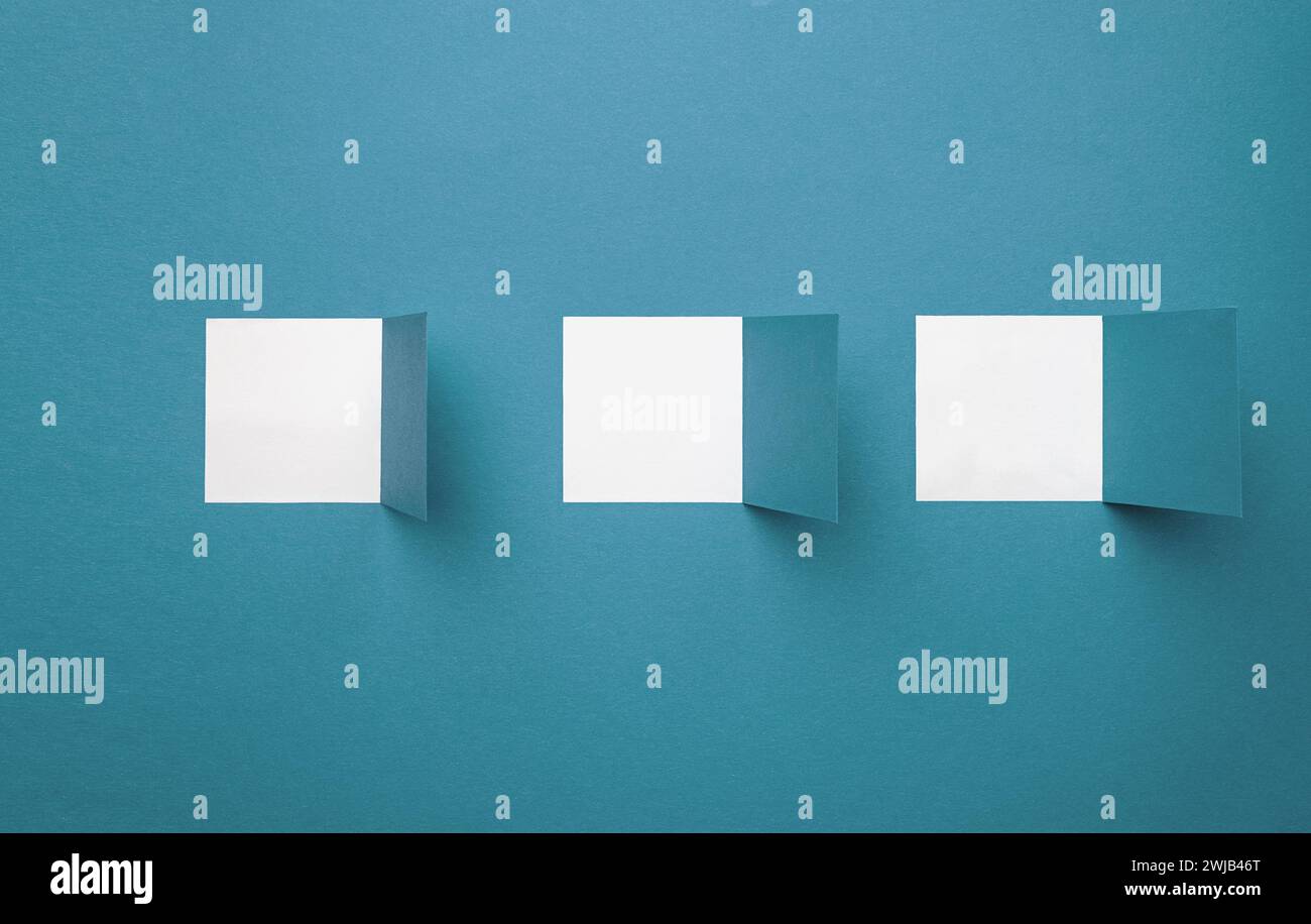 Square shaped holes on blue paper on white background. Minimal creative ...