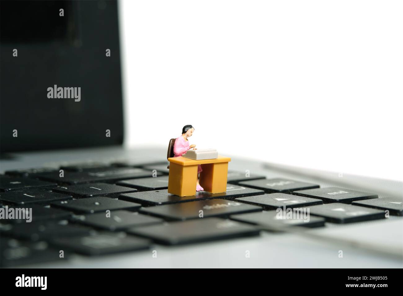 Miniature tiny people toy figure photography. A woman seat in the desk ...